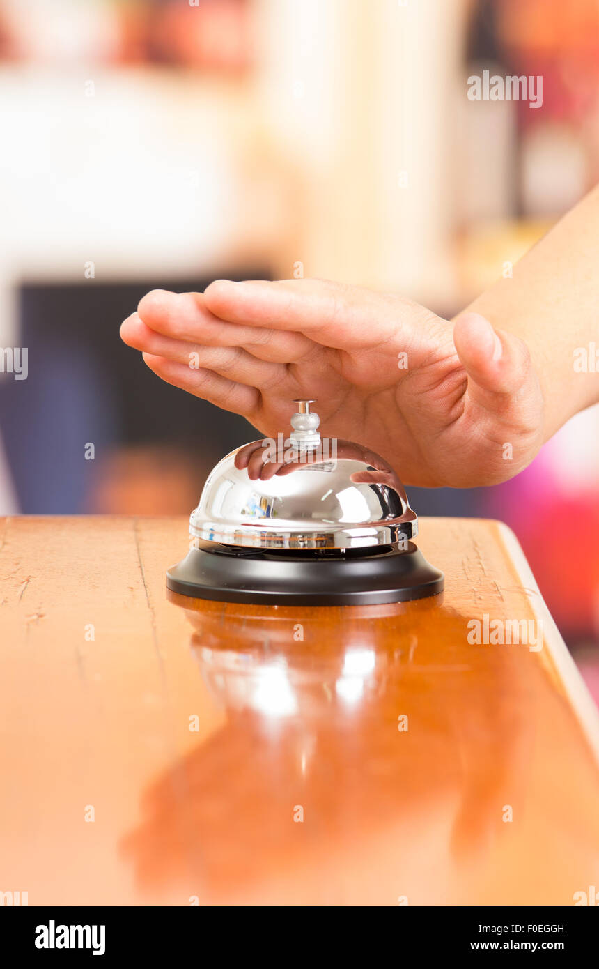 hand ringing hotel bell in reception desk close up selective focus ...