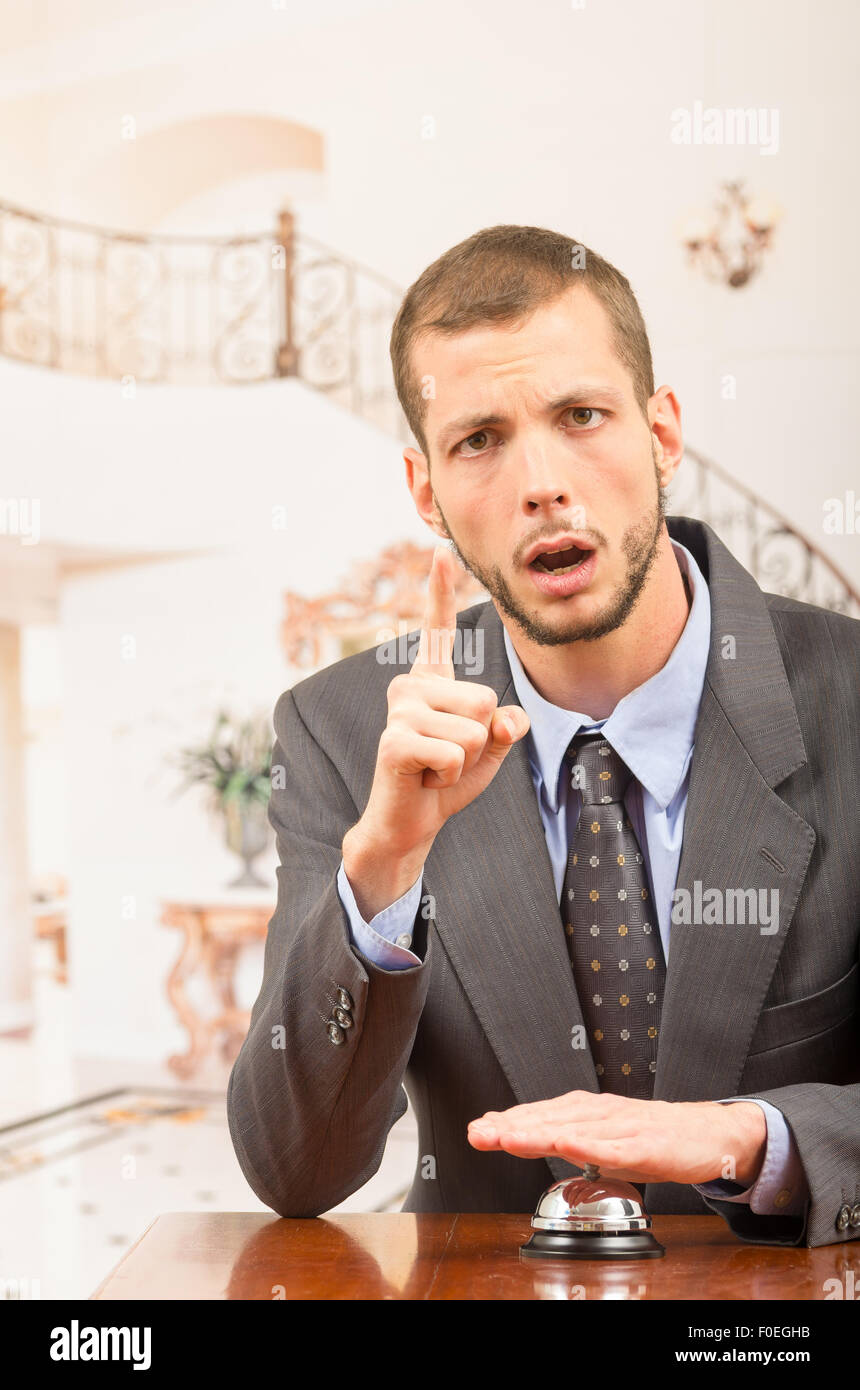Upset guest customer ringing hotel bell at reception desk Stock Photo ...