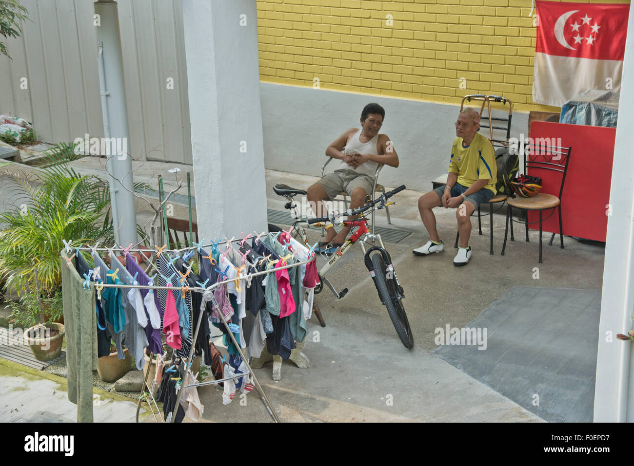 Neighbours chat with flags displayed in social housing HDB tower blocks ...