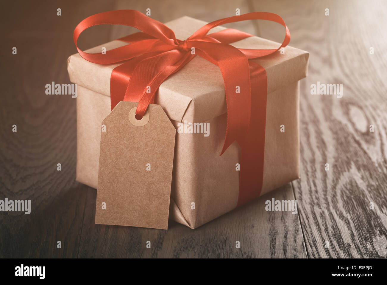 rustic present box with red ribbon on wood table Stock Photo - Alamy