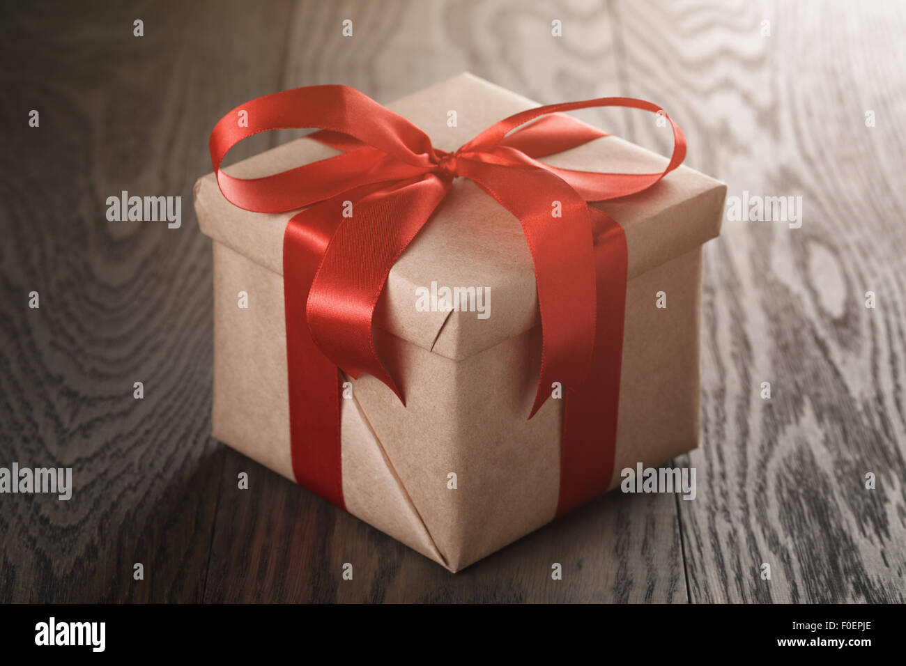 rustic present box with red ribbon on wood table Stock Photo - Alamy