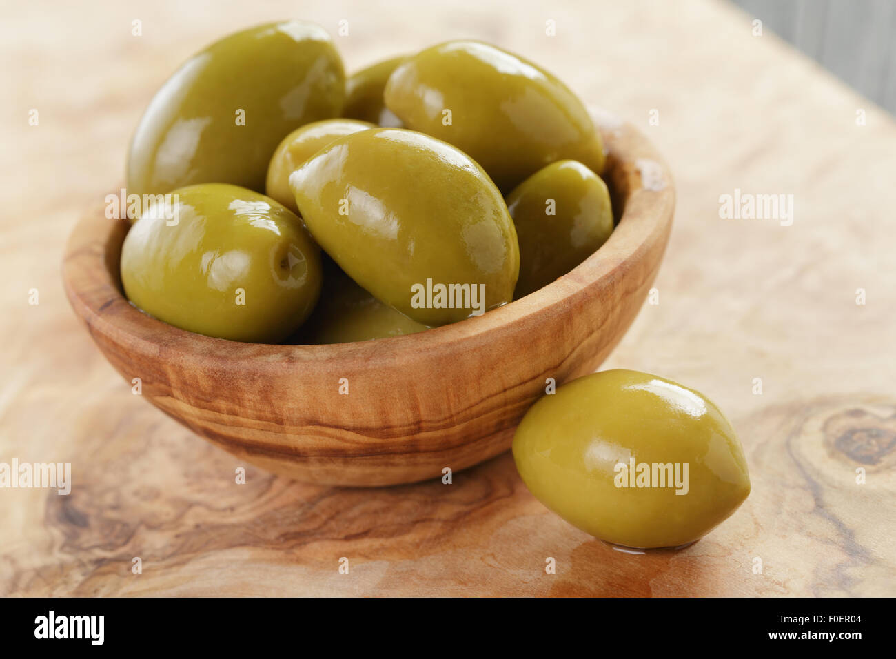 salted giant green olives in olive bowl on wooden table Stock Photo - Alamy