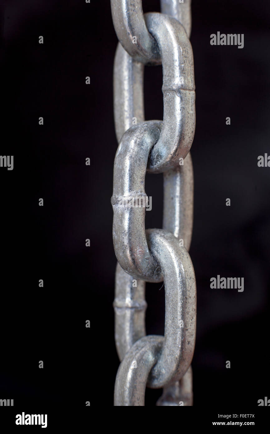 vertical picture with part of metal chrome chain against dark ...