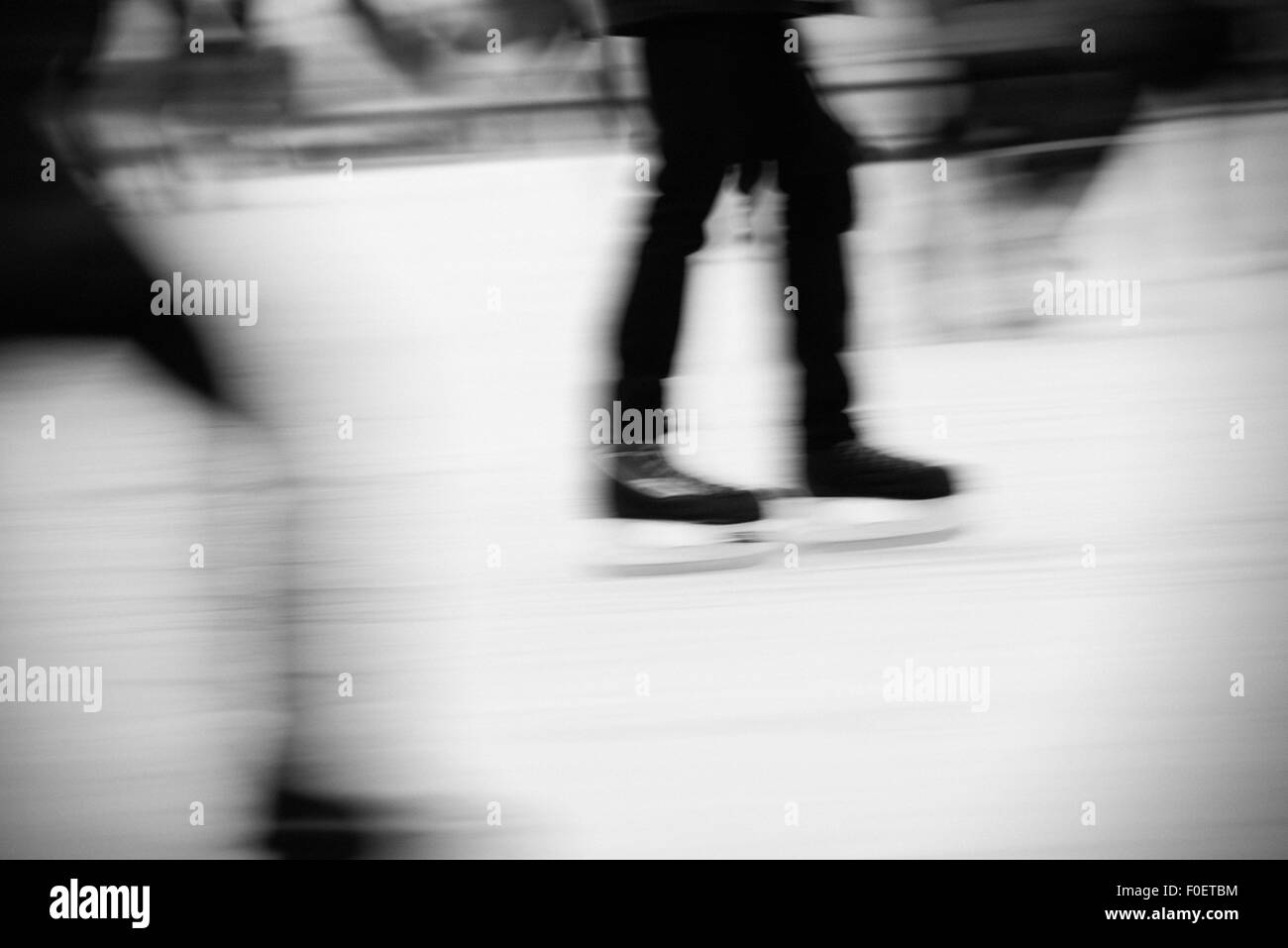 Side view of people ice skating in park. Motion blur showing speed and ...