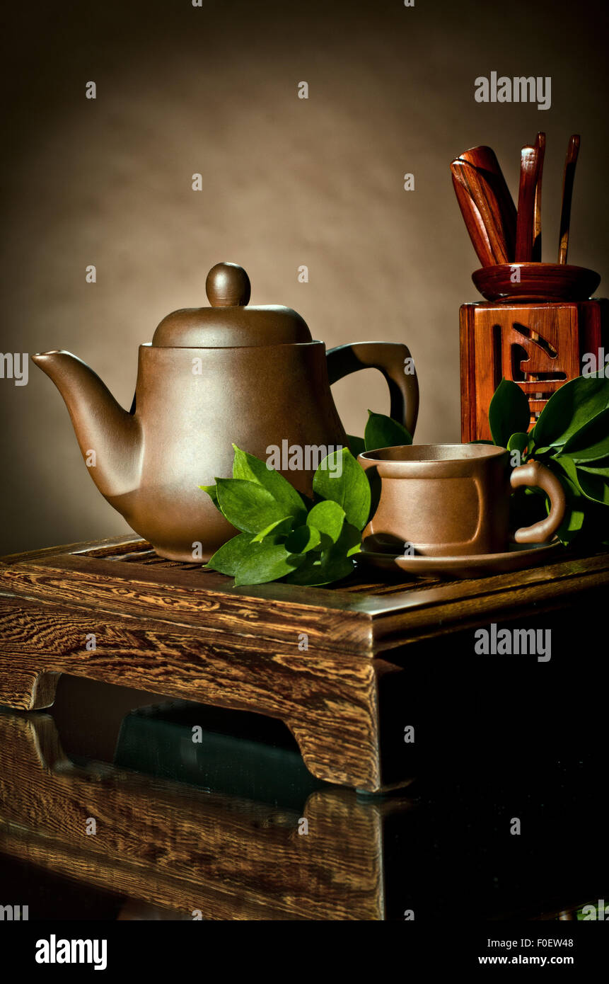 vertical photo, still life of the clay teapot and cup on brown ...