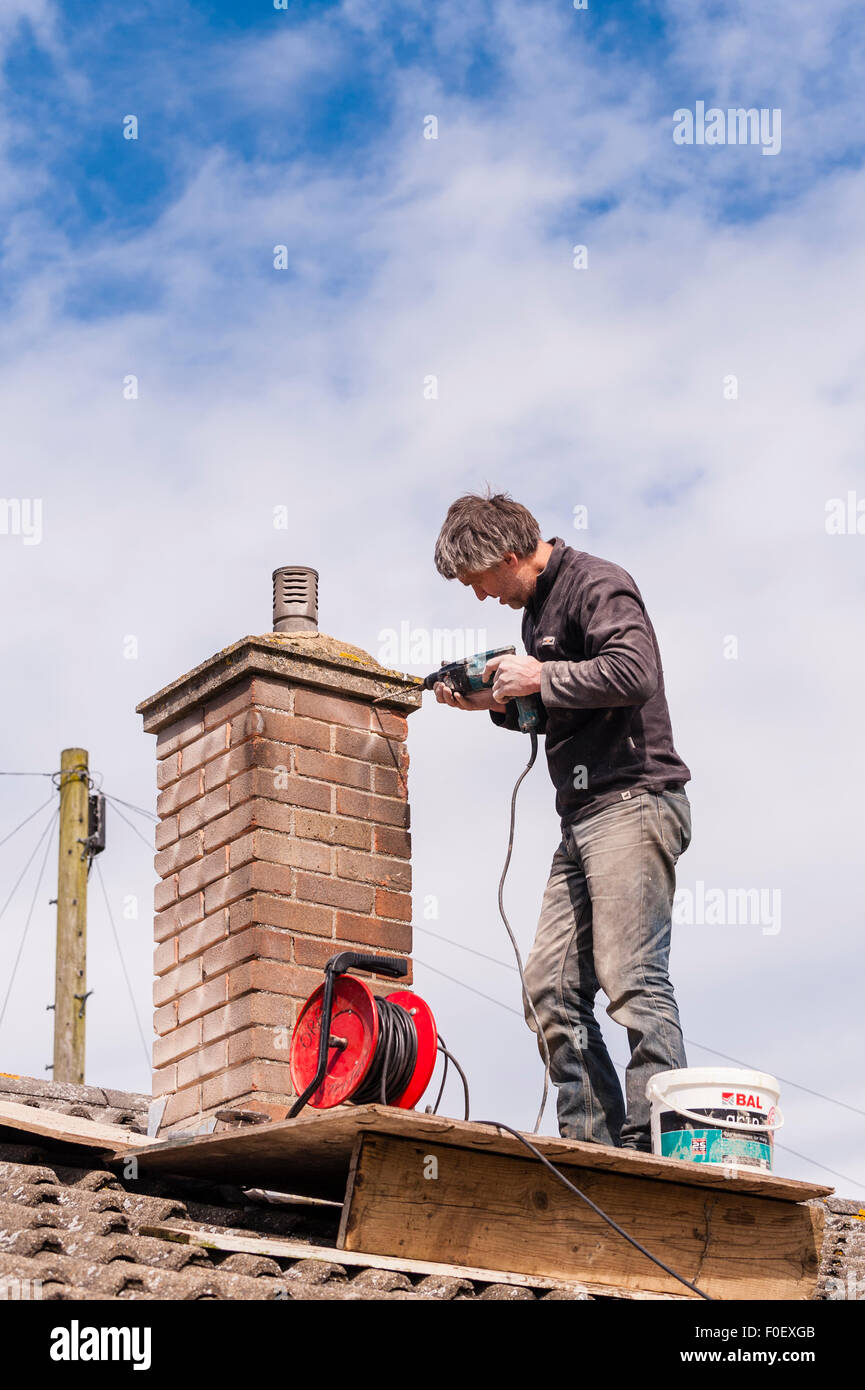 A Builder in the process of repointing a chimney in the UK Stock Photo ...