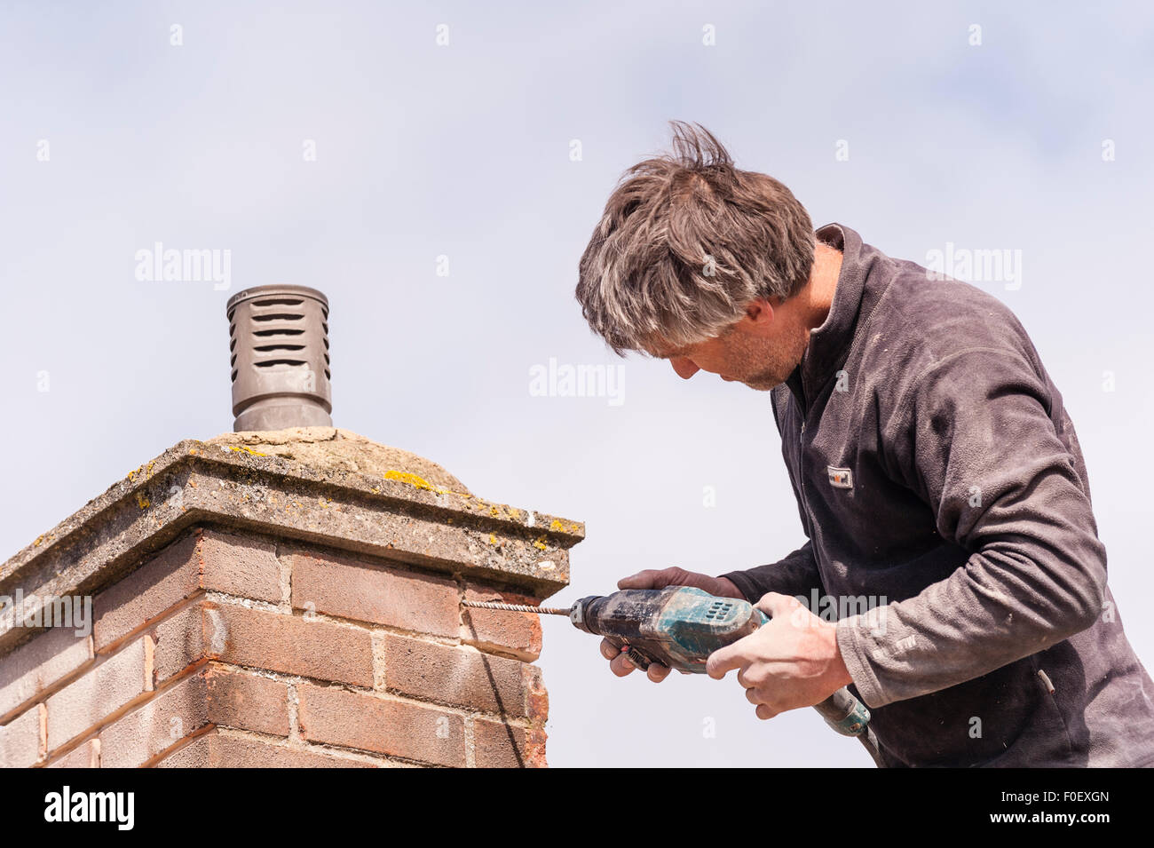 A Builder in the process of repointing a chimney in the UK Stock Photo ...