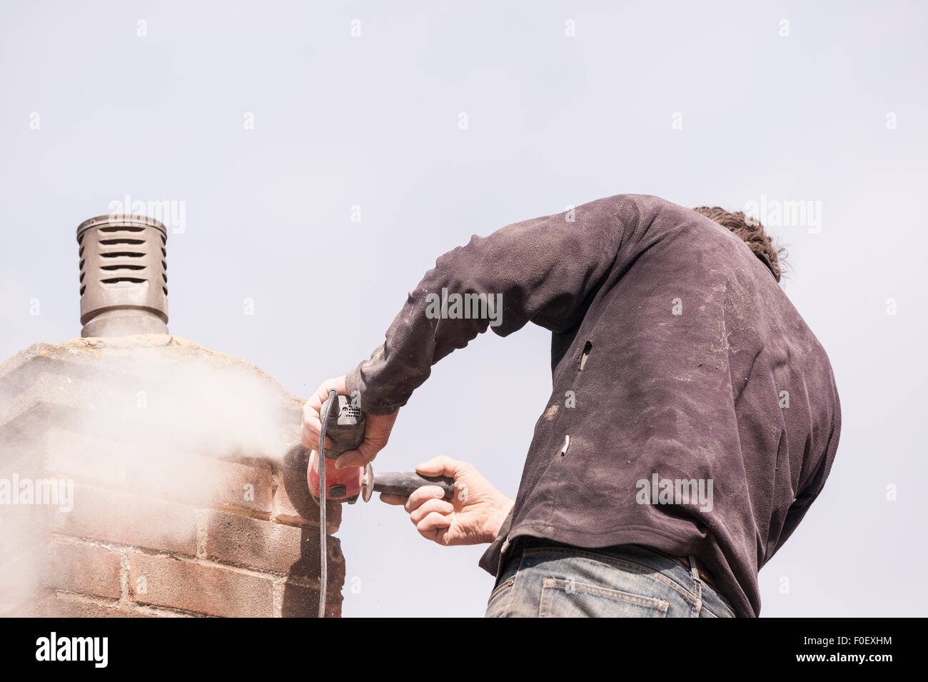 A Builder in the process of repointing a chimney in the UK Stock Photo ...