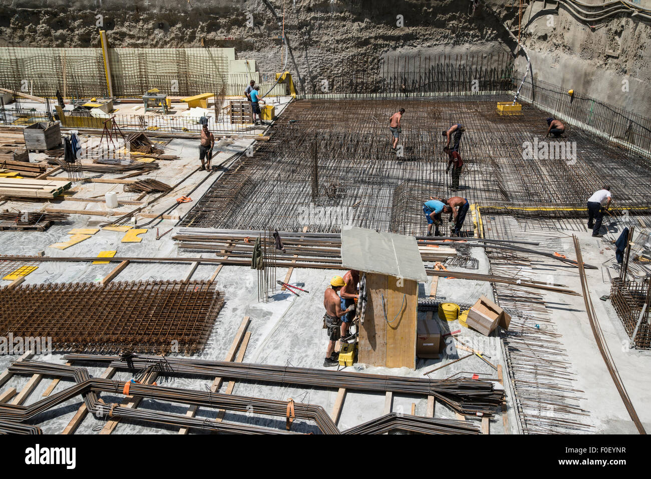 Basement construction engineering with a group of men placing steel ...