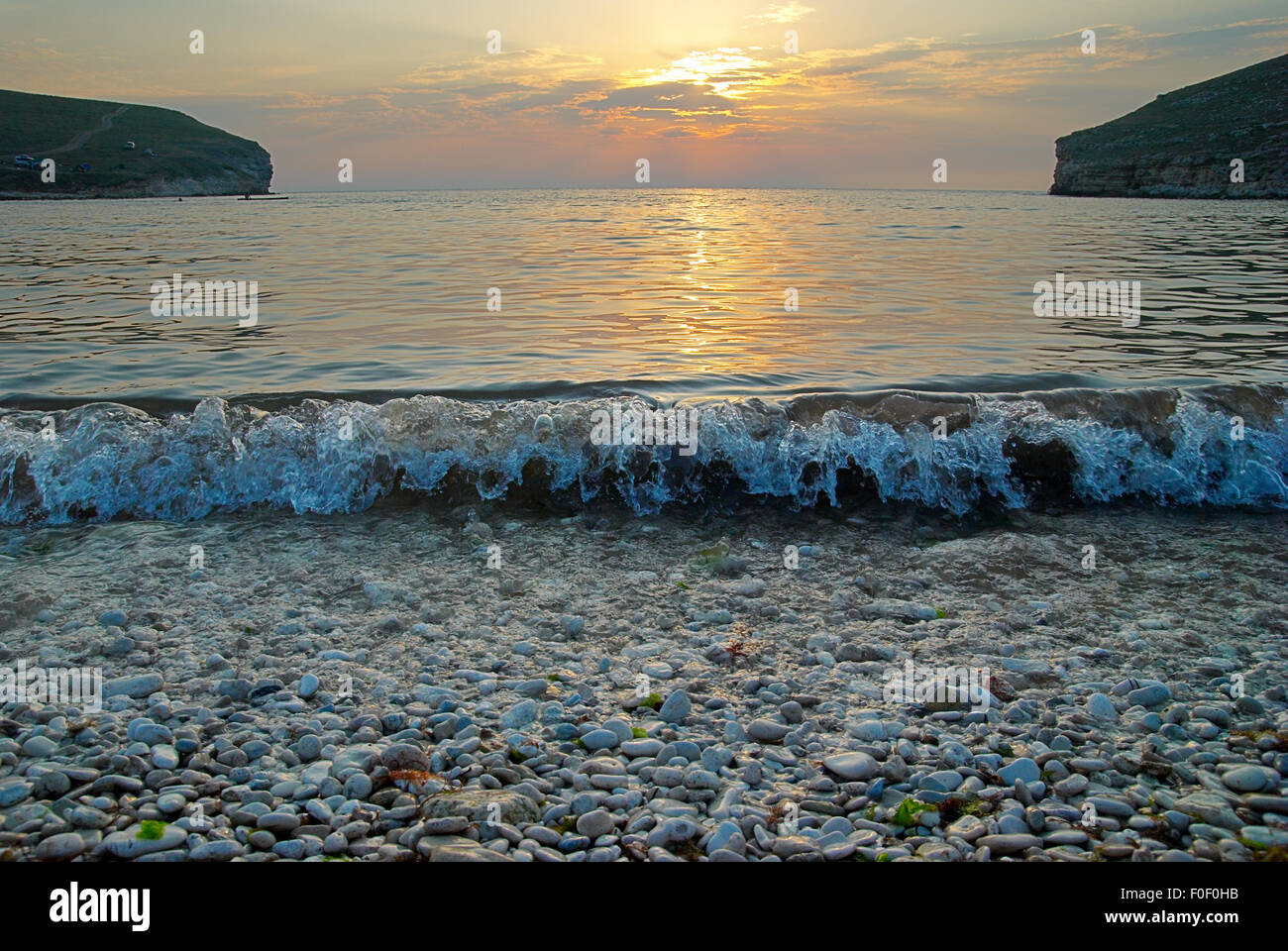 Sunset on the sea with the waves Stock Photo - Alamy