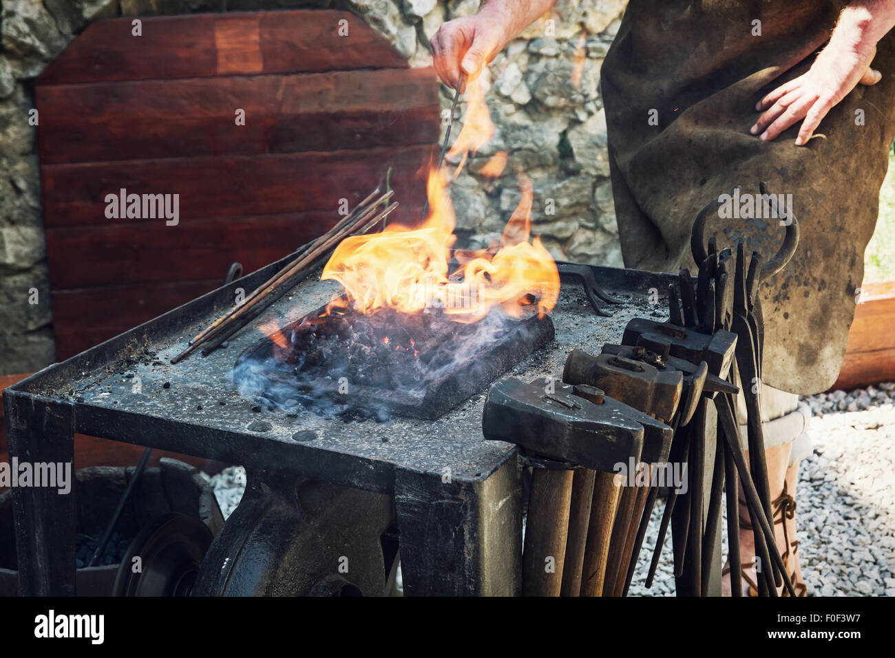 Artistic blacksmith works in the historic blacksmith workshop. Retro ...