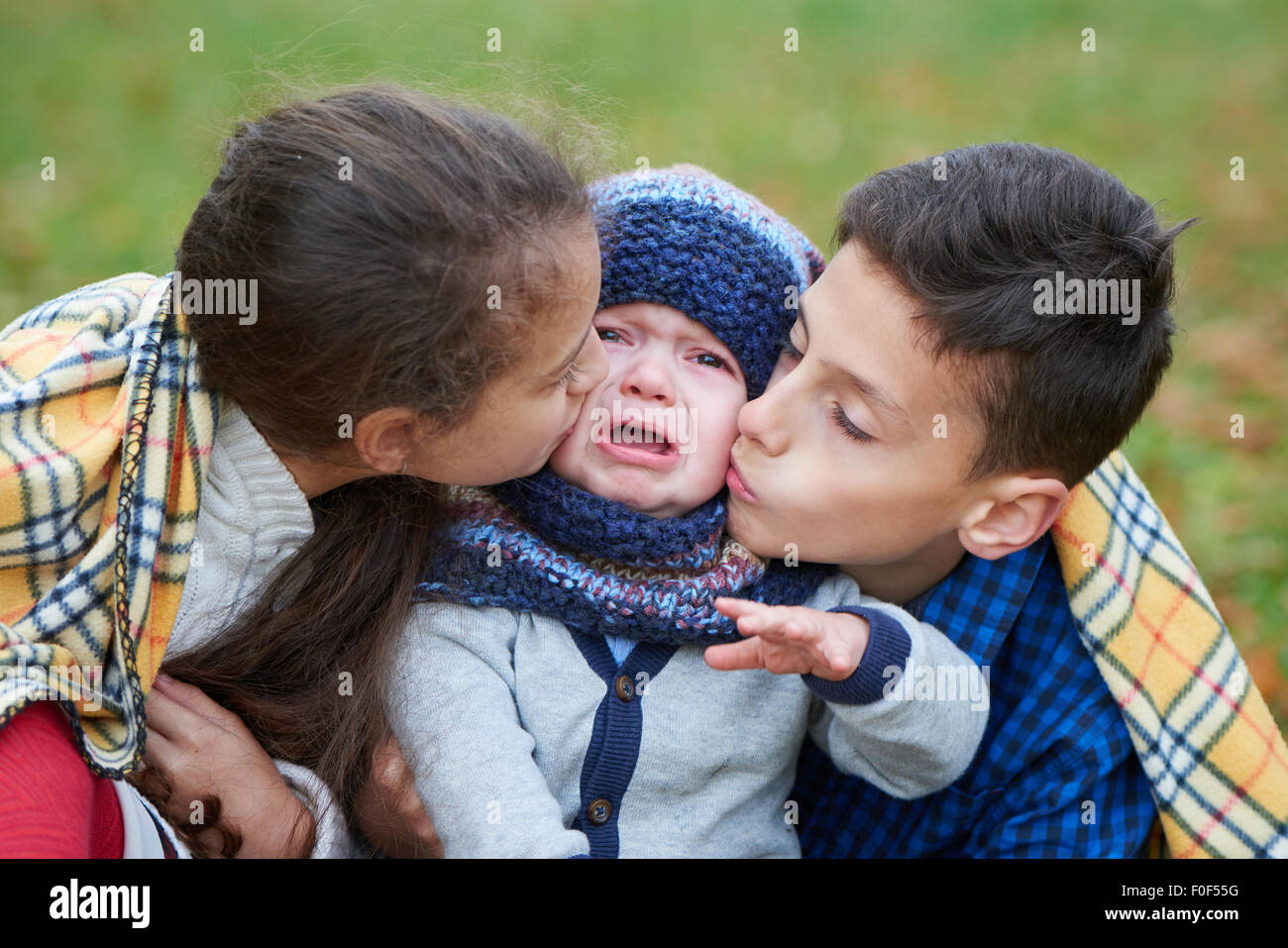 boy and girl comforting crying brother Stock Photo - Alamy