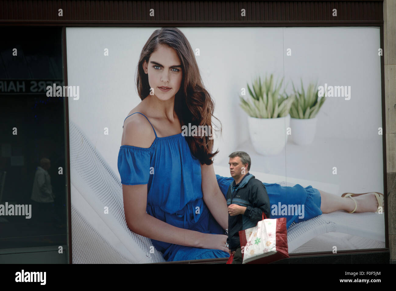 Man Walking Past Advertising In Store Window Stock Photo - Alamy