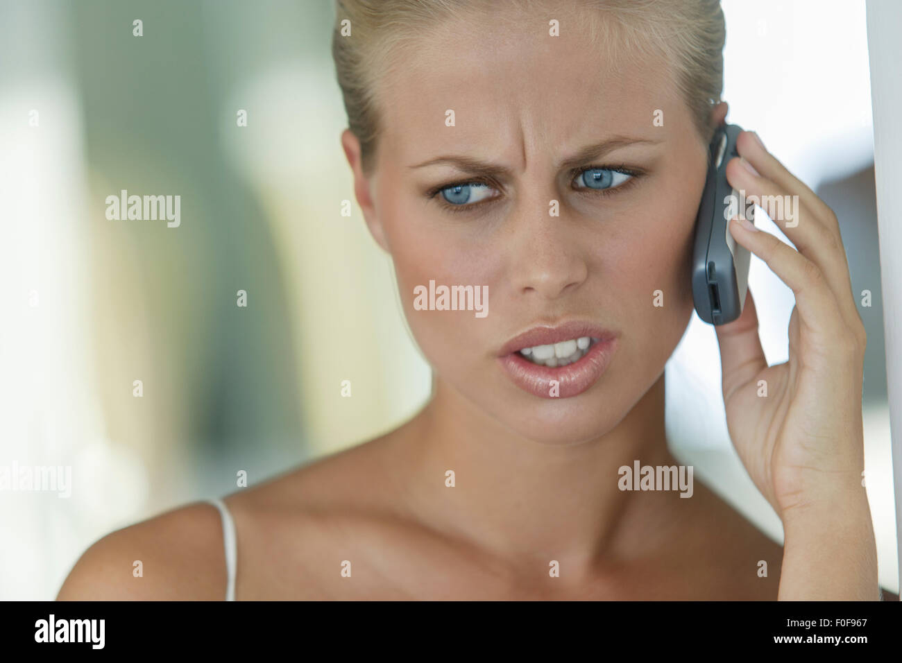 Angry young woman talking on mobile phone Stock Photo - Alamy