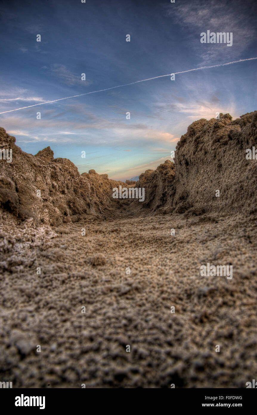 photo from the bottom of a tire rut through soft lightly colored sand ...