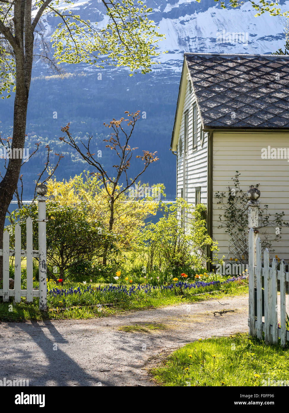 View of snow-covered mountains, fjord , white wooden house, spring ...