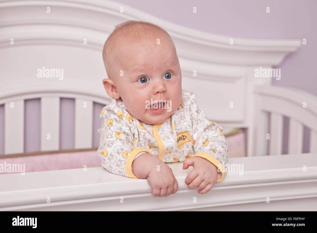 Happy baby standing in crib Stock Photo - Alamy