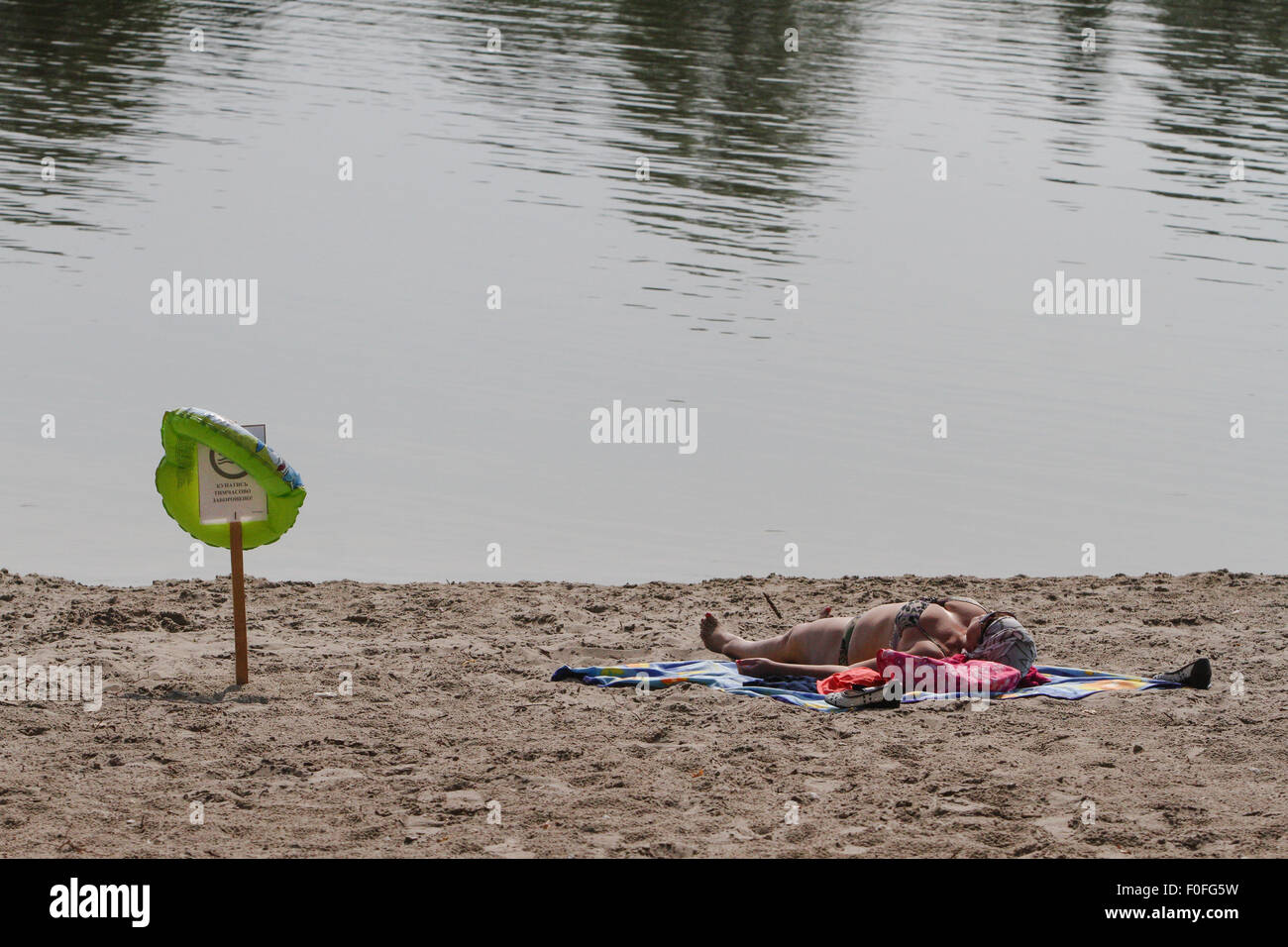 Kiev, Ukraine. 13th Aug, 2015. A woman is sunbathing on Verbne lake ...