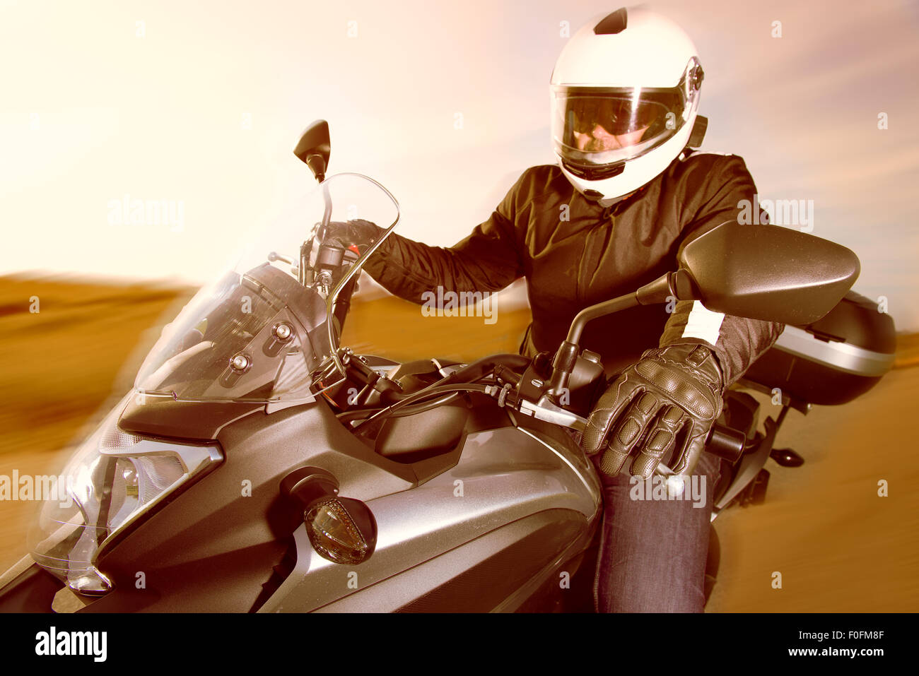 Biker in helmet and leather jacket riding on the road Stock Photo - Alamy
