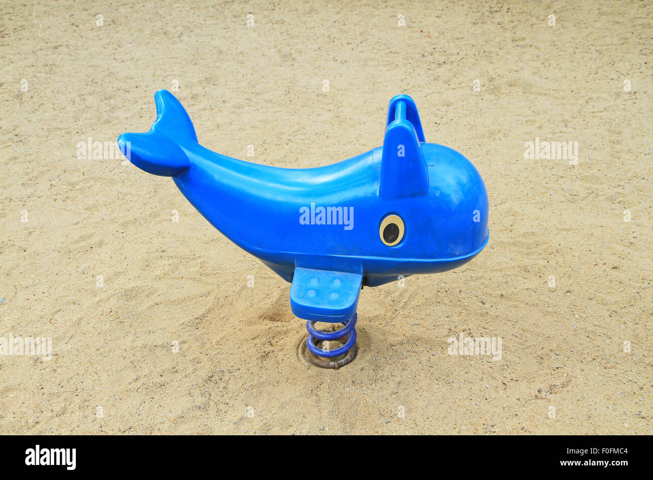Spring blue dolphin on sand floor playground Stock Photo - Alamy