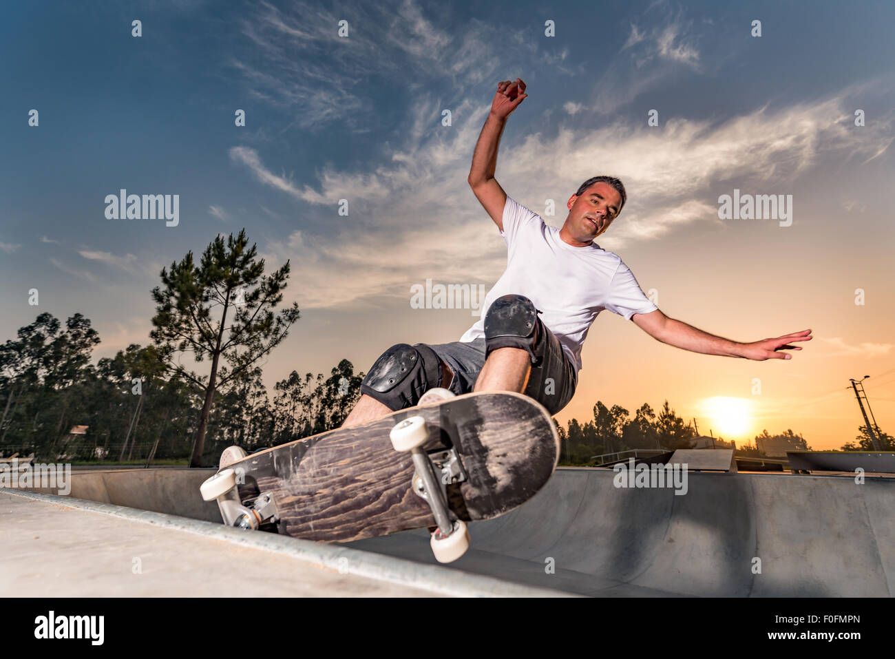 Skateboarder in a concrete pool at skatepark on a beatiful sunset Stock ...