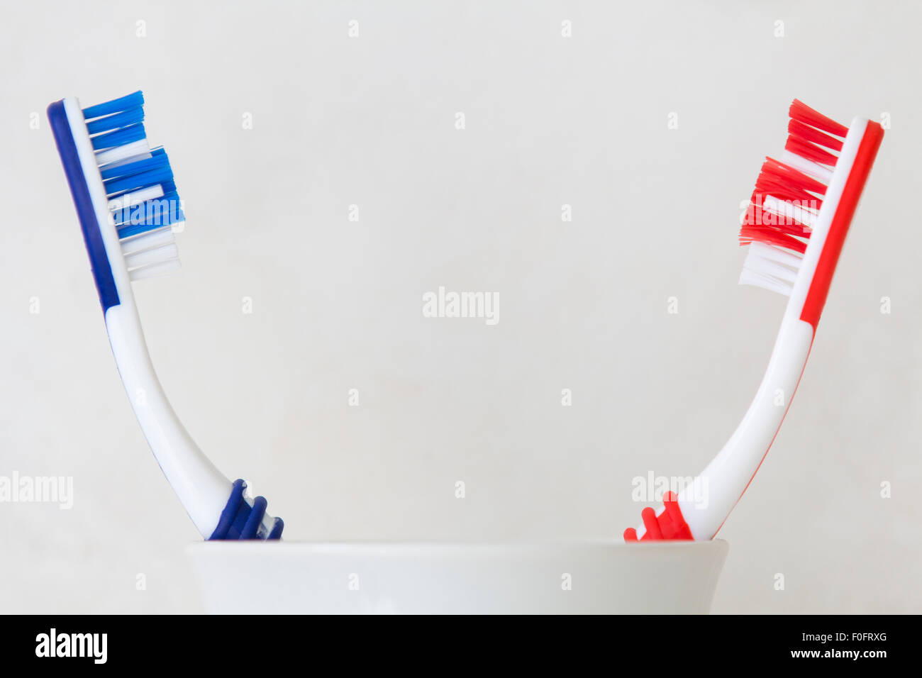 Two toothbrushes in a cup being displayed in the bathroom Stock Photo ...