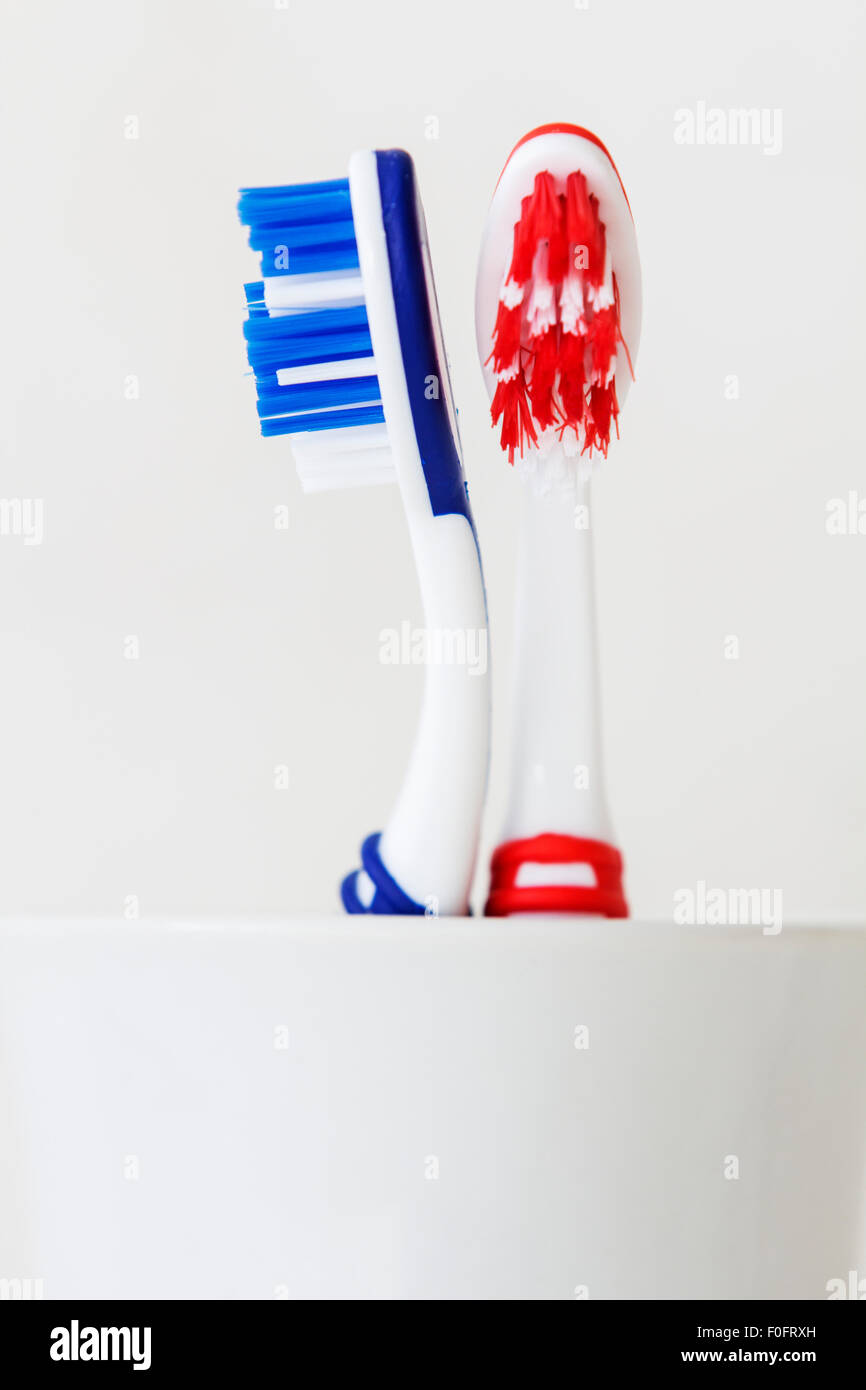 Two toothbrushes in a cup being displayed in the bathroom Stock Photo ...