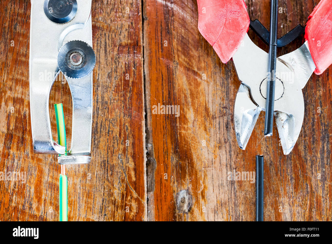 small nippers with black red handles on wooden board Stock Photo - Alamy