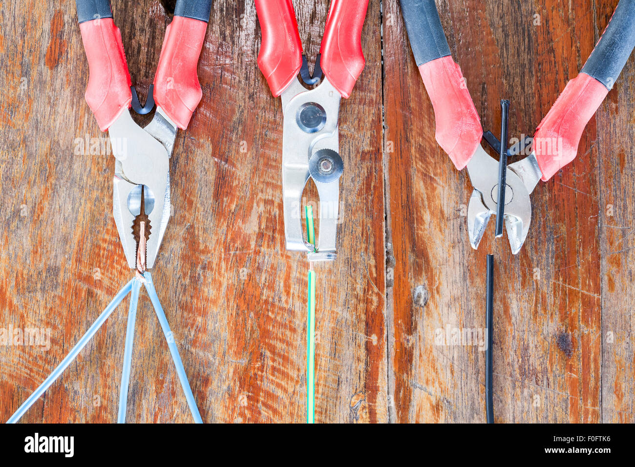 small nippers with black red handles on wooden board Stock Photo - Alamy