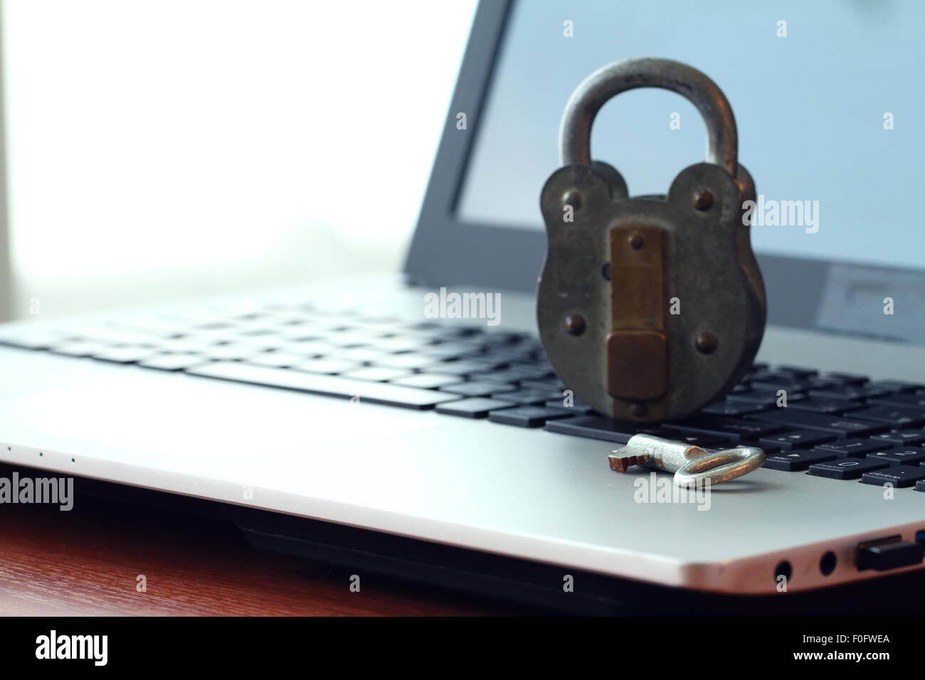 Internet security concept-old padlock and key on laptop computer ...