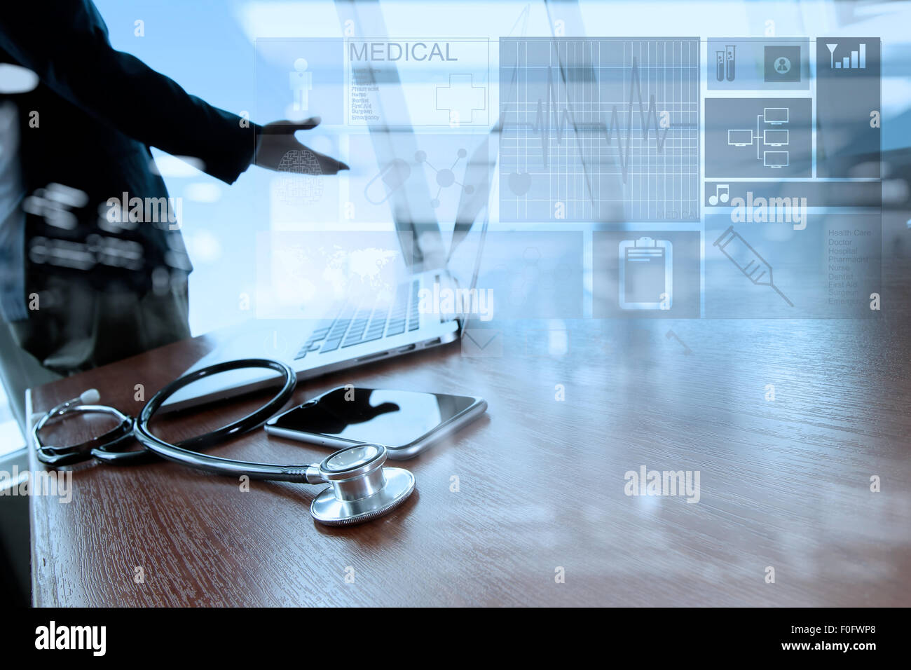 Doctor working with digital tablet and laptop computer in medical ...