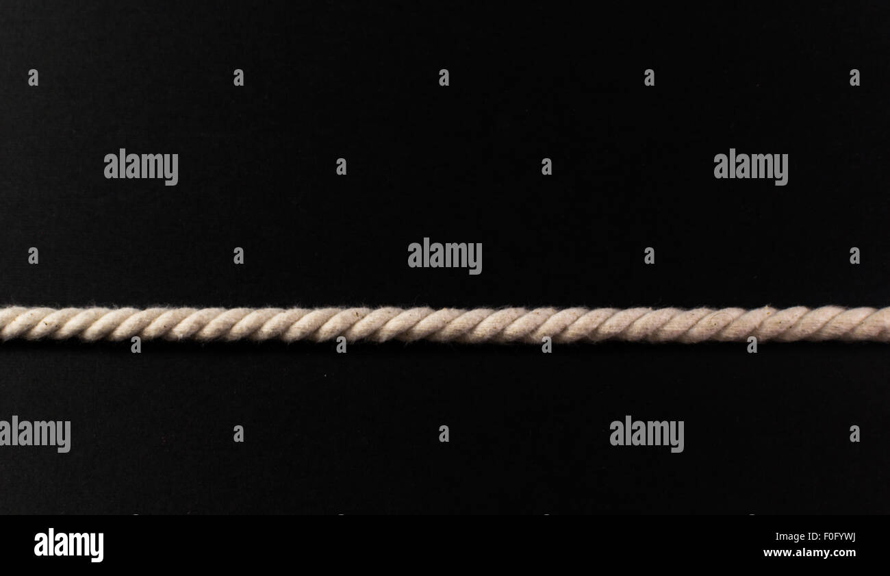 Simple taut strand of white rope on a black background Stock Photo - Alamy