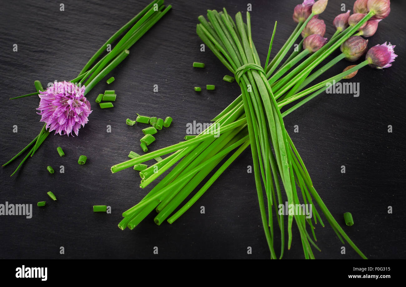 Fresh green chive on a black background. Top view Stock Photo - Alamy