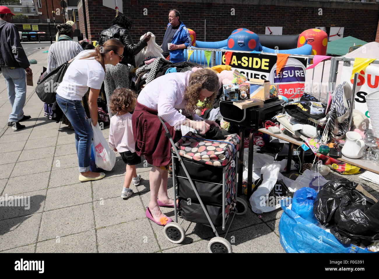 People sorting through secondhand items at a jumble sale at the Geffrye ...