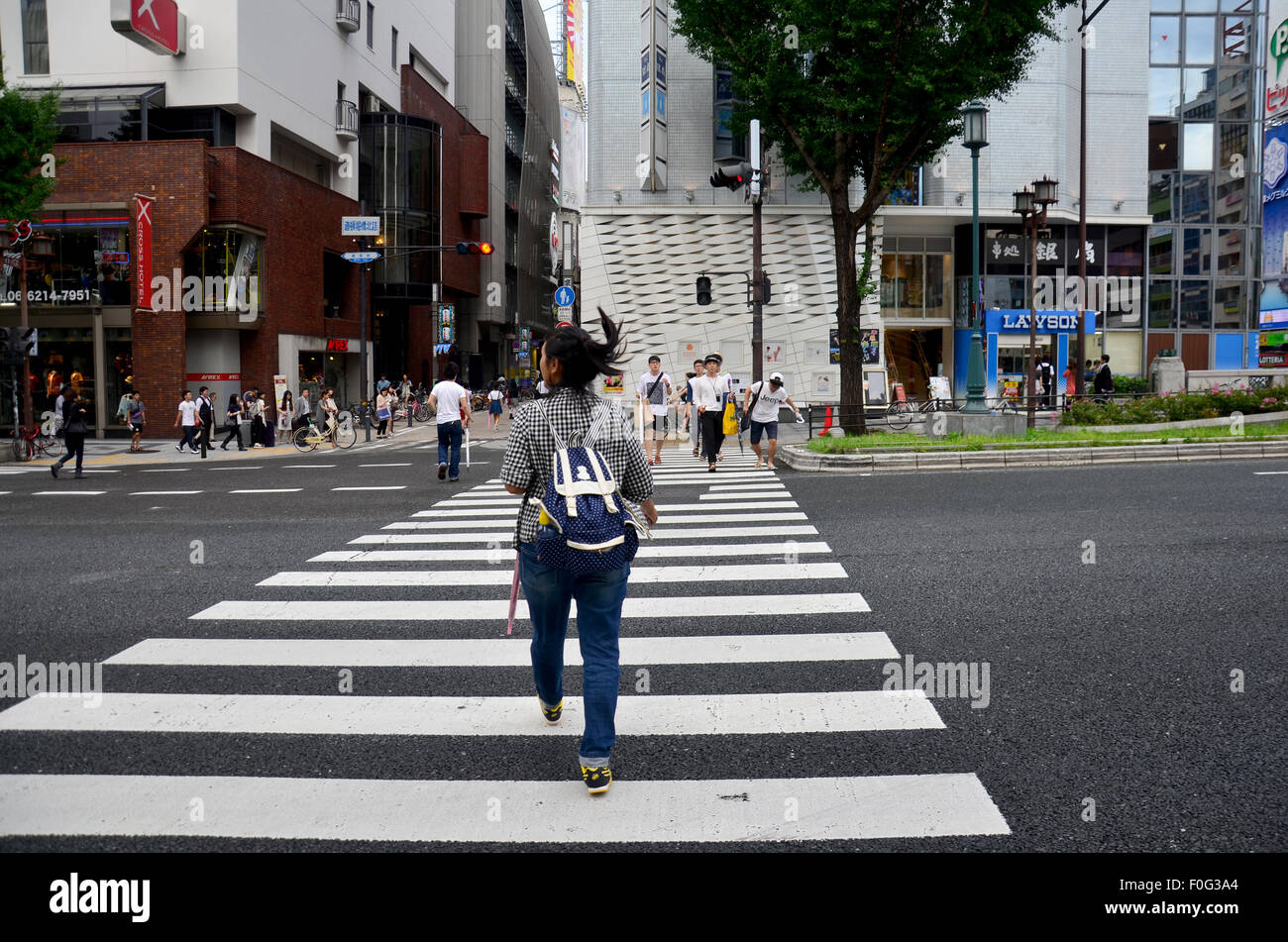Thai women walk cross over road at crosswalk go to Dotonbori on July 7 ...