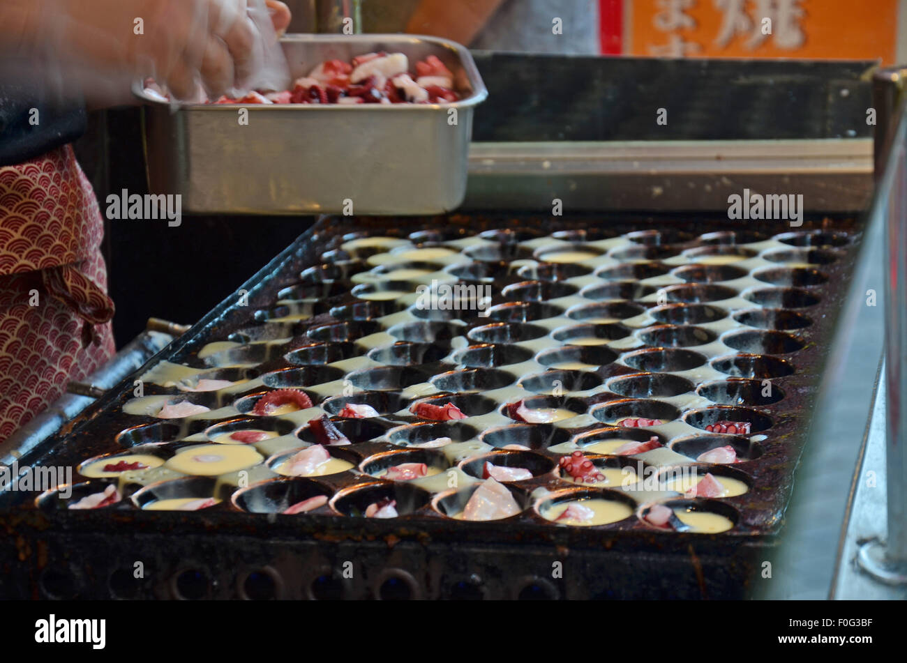 Cooking takoyaki is a ball-shaped Japanese snack at Dotonbori in Osaka ...