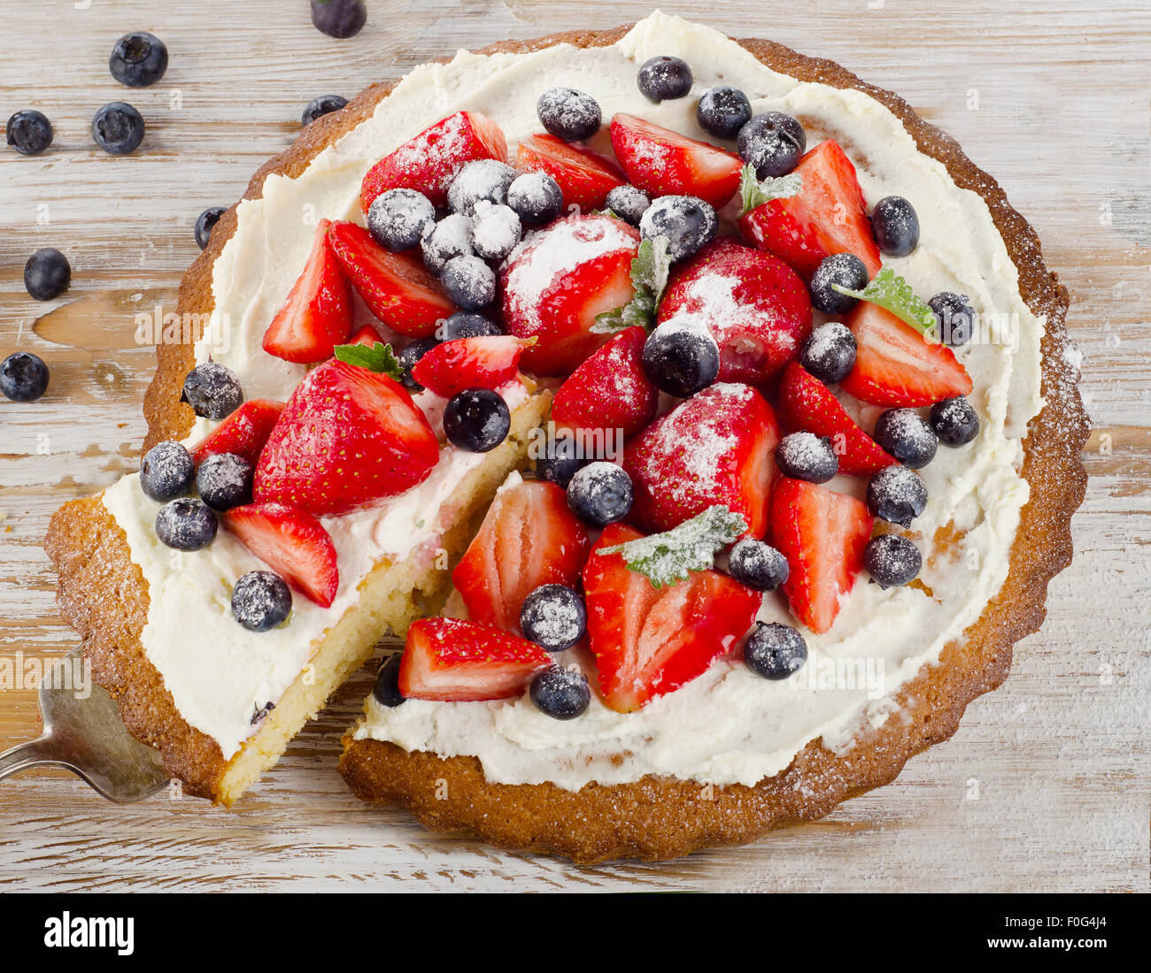Cake with fresh berries on white wooden background Stock Photo - Alamy
