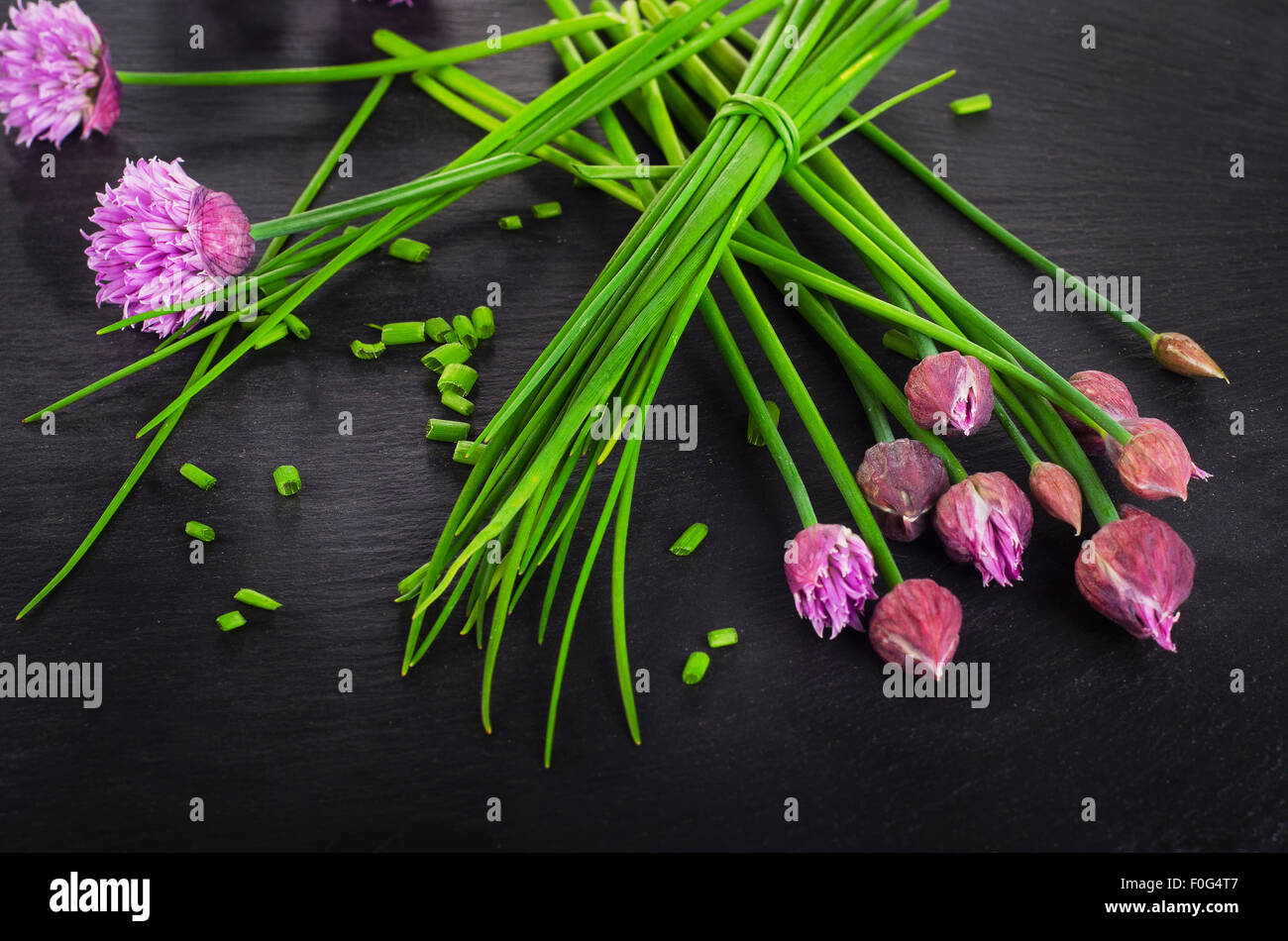 Fresh green chives on a black background. Top view Stock Photo - Alamy