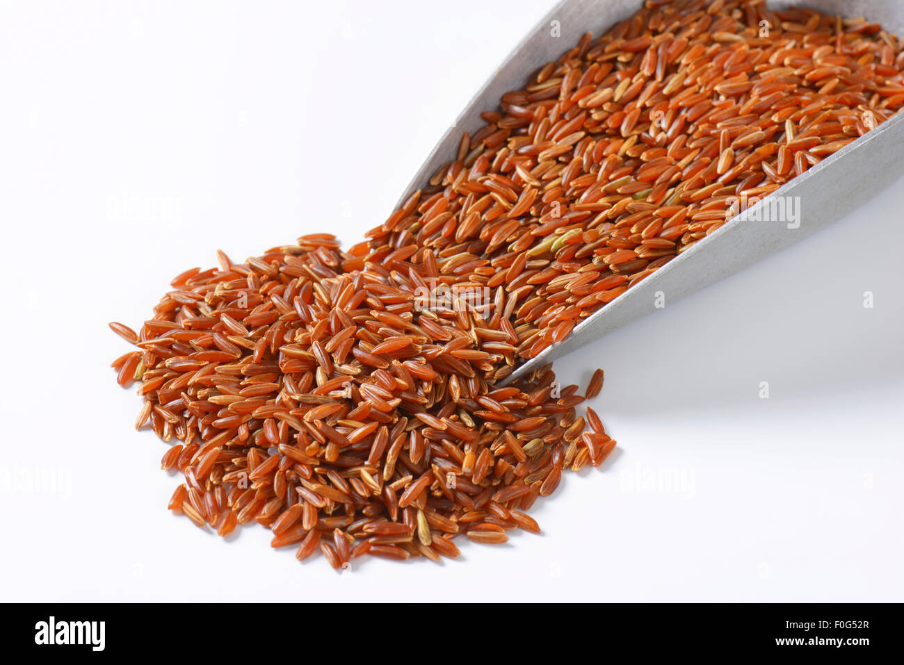 Scoop of uncooked red rice Stock Photo - Alamy
