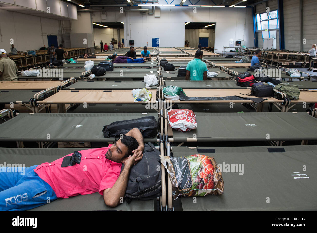 Stuttgart, Germany. 15th Aug, 2015. A refugee lies on a camp bed in one ...