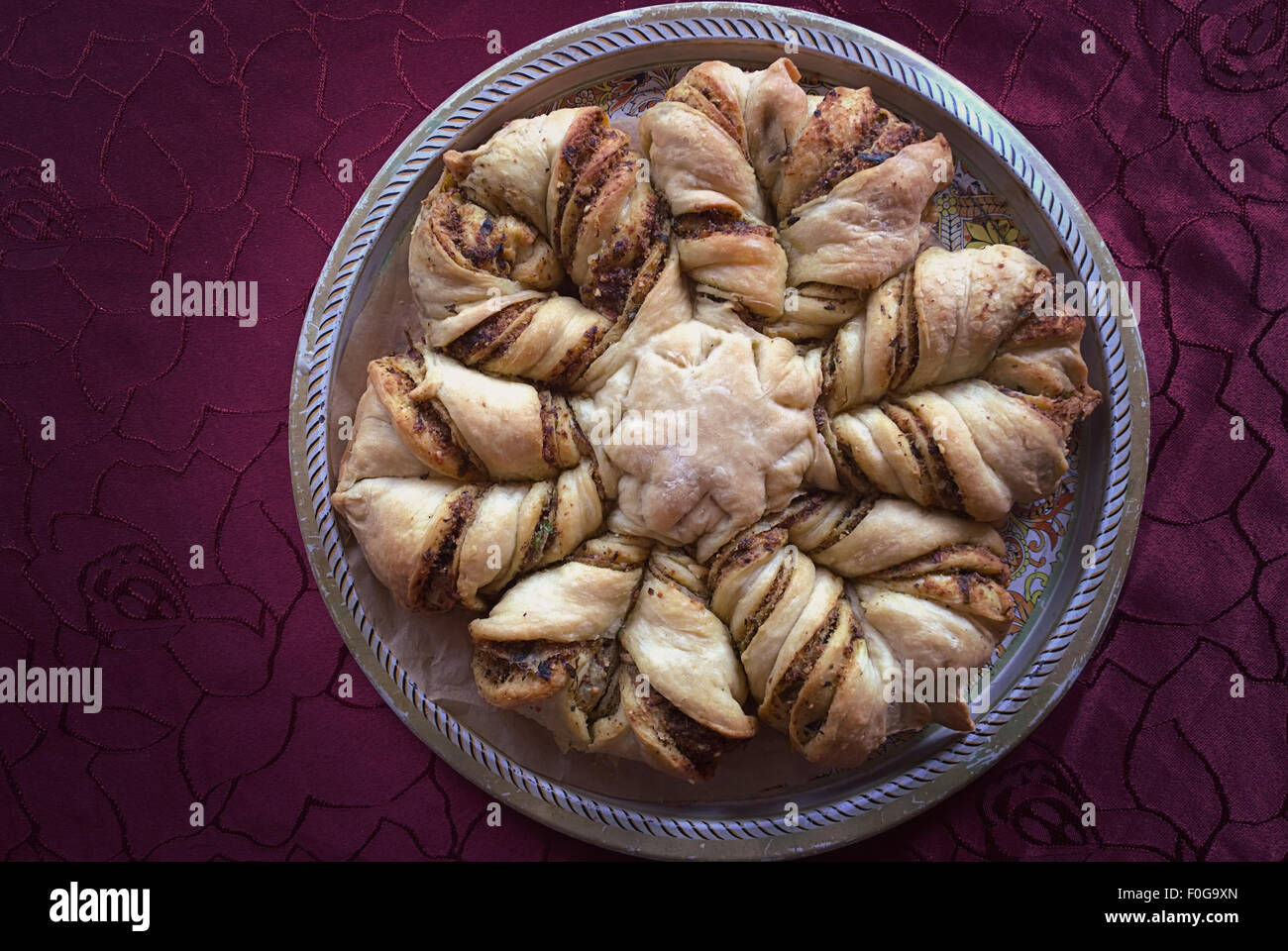Rich and spiced bread with sunflower shape on a purple damask ...