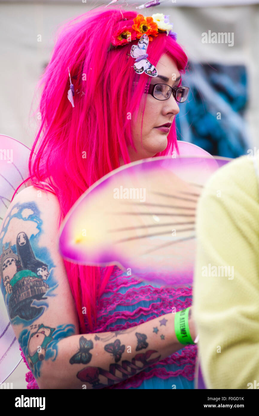 Woman dressed as fairy with pink hair and tattoos on arm at the New ...