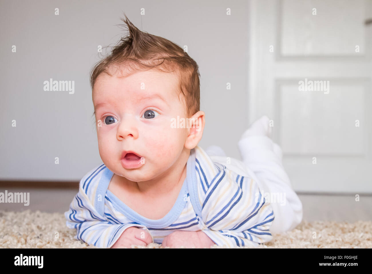 2 months old baby boy enjoying tummy time on the carpet at home Stock ...