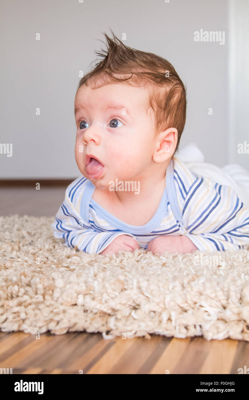 2 months old baby boy enjoying tummy time on the carpet at home Stock ...
