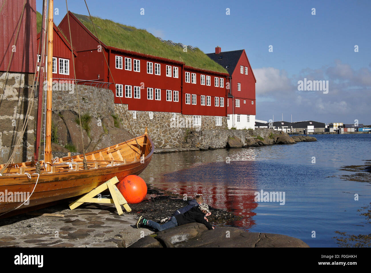 Turf-roofed buildings and sailboat on Tinganes Peninsula, Torshavn ...