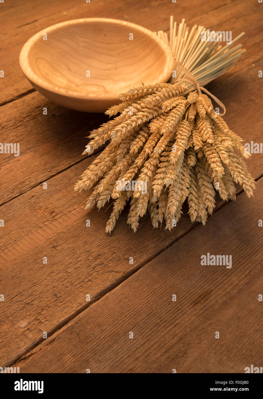 Sheaf of wheat on rustic table Stock Photo - Alamy
