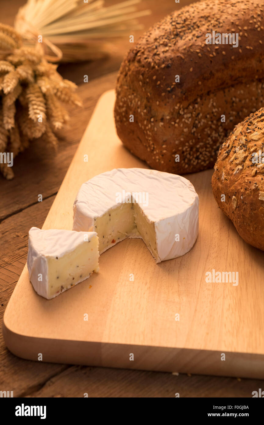 Bread and cheese on chopping board and rustic background Stock Photo ...