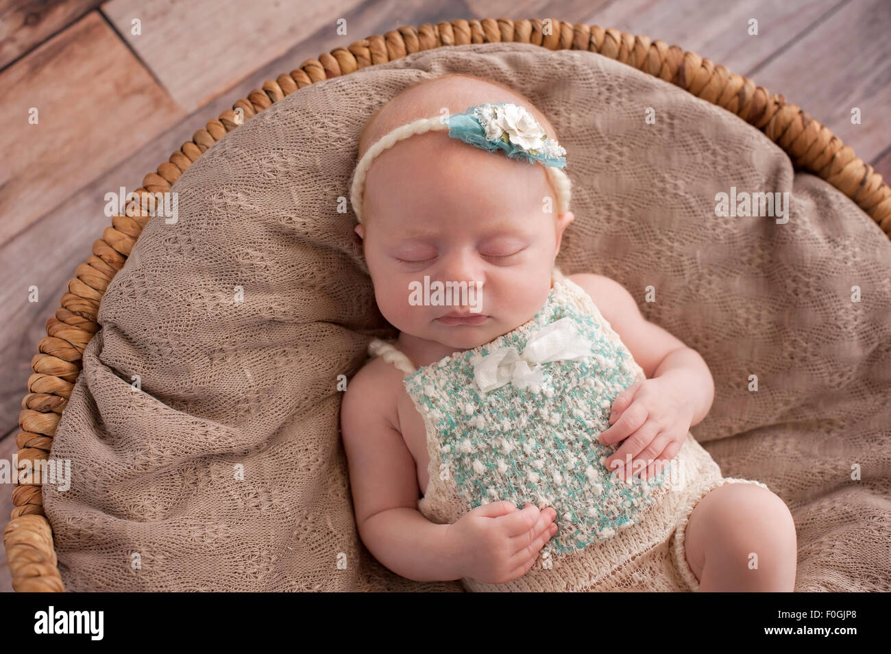 A seven week old baby girl sleeping in a wicker basket. Shot in the ...