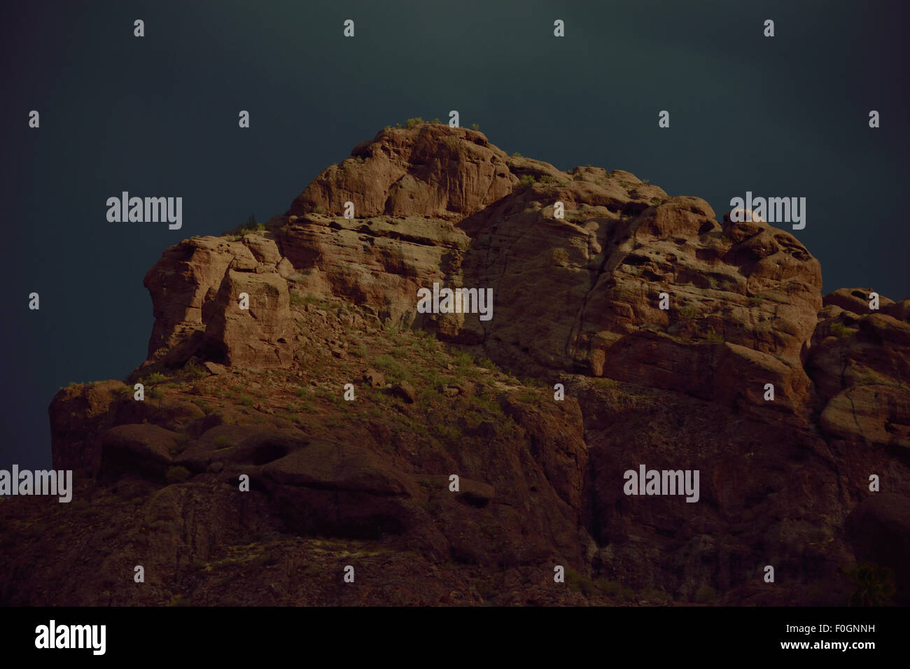 Dark clouds cover the top of a rocky mountain top Stock Photo - Alamy
