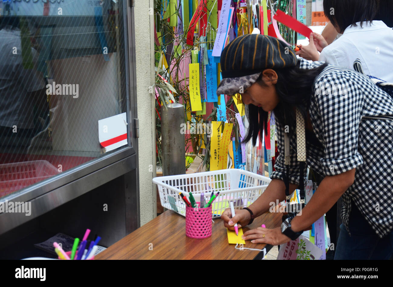 Thai woman writing wishes small pieces of paper, and hanging them on ...